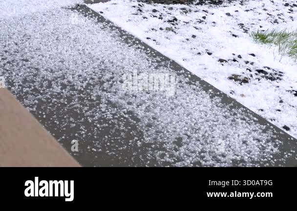 A detailed image showing a close-up view of hailstones densely covering ...