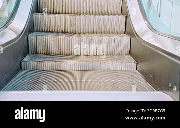 Close up view of moving escalator steps going upward with metallic ...