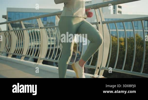 A woman dressed in stylish activewear jogs energetically and with ...