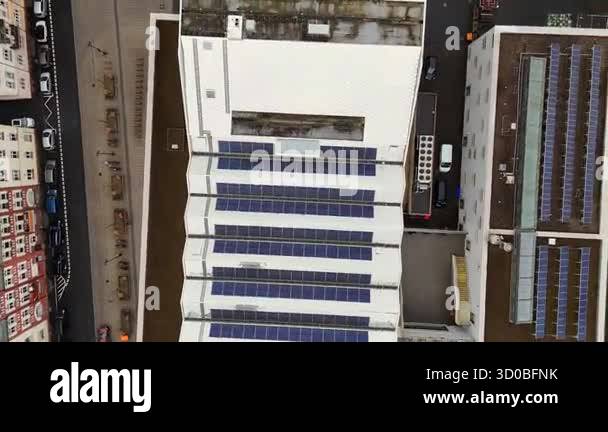 Aerial view of modern industrial rooftops with solar panels and parking ...