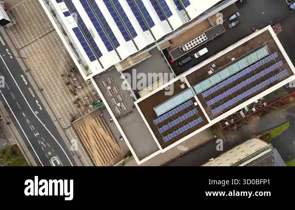 Aerial view of urban buildings with solar panel rooftops, parking area ...