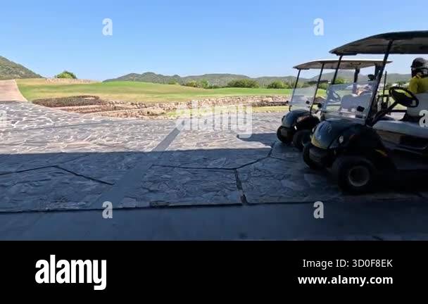 Golf cart driving over a stone-paved path Stock Video Footage - Alamy