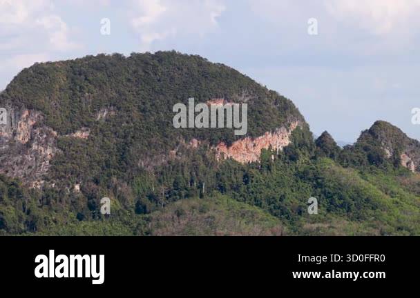 A serene view of lush, green mountains under a bright sky, captured ...