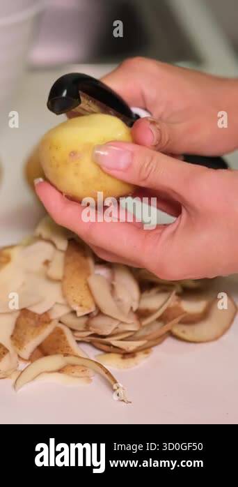 Closeup of skilled hands peeling a fresh potato, showcasing cooking ...