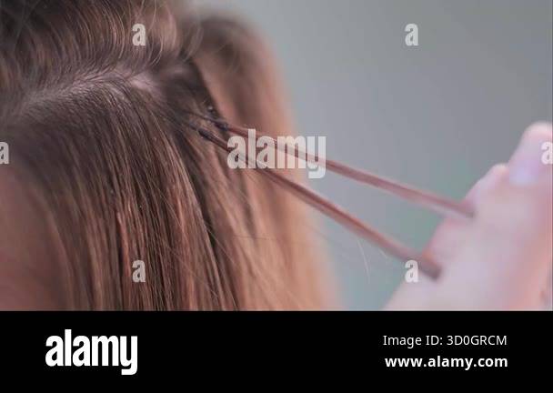 Young woman holding hair strand with capsule creating long thick ...