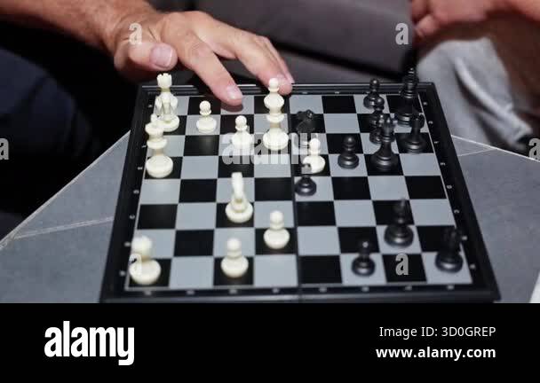 Closeup a chess game with strategic moves is being played between two ...