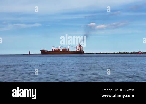 A cargo ship leaves the port on a voyage delivering cargo. High quality ...