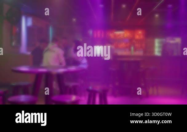 neon lit nightclub interior with friends, two people chatting near bar ...