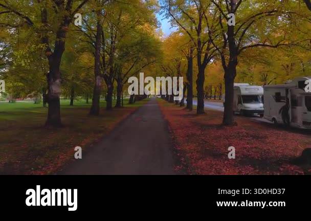 Aerial forward glide down a tree lined promenade in Riga, Latvia ...