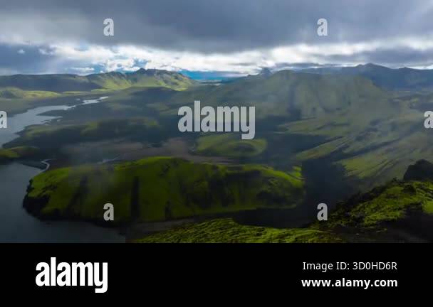 Aerial view of moss covered hills, black volcanic terrain, and a ...