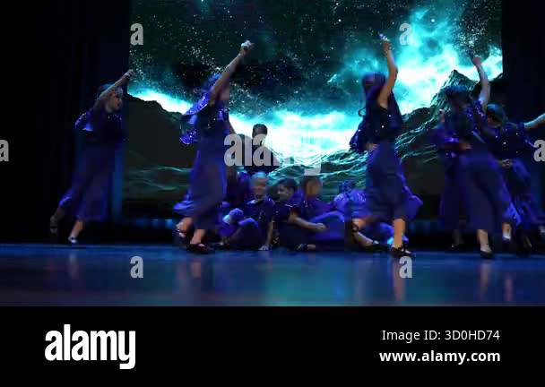 Preteen dancers in purple sequins perform synchronized moves on a ...
