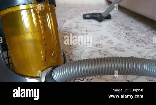Cleaning carpet with vacuum cleaner. Dust is spinning in yellow ...