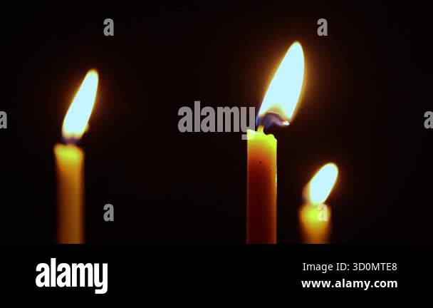 Burning candle flames glowing in the dark, symbolizing warmth, hope ...