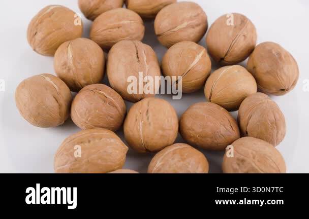 Group of Walnuts. A cluster of whole walnuts rotates slowly ...