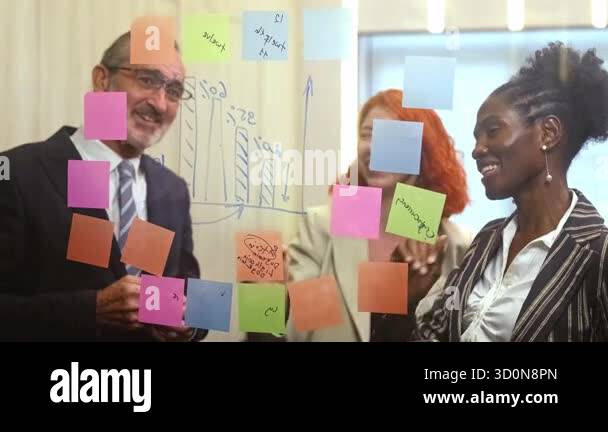 Diverse professionals brainstorming in an office, smiling and planning ...