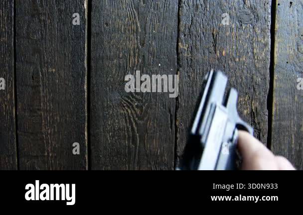Hand puts a gun on a wooden background Stock Video Footage - Alamy