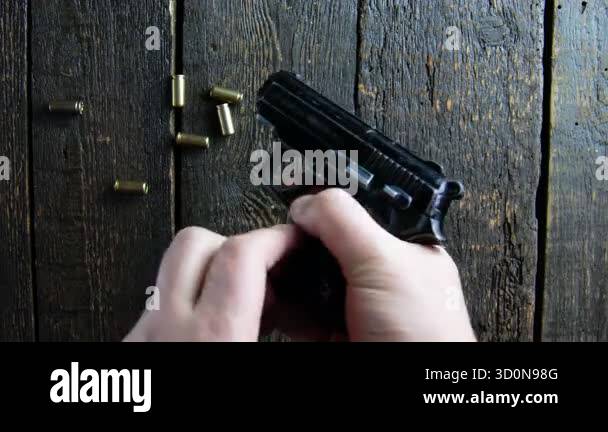 Hand puts a gun on a wooden background Stock Video Footage - Alamy