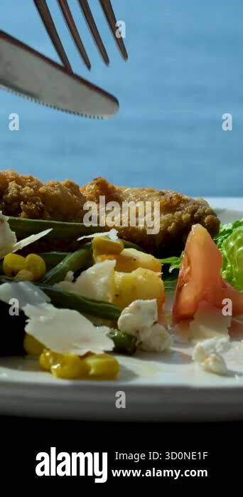 Woman enjoying tropical lunch at beachfront restaurant, wearing straw ...