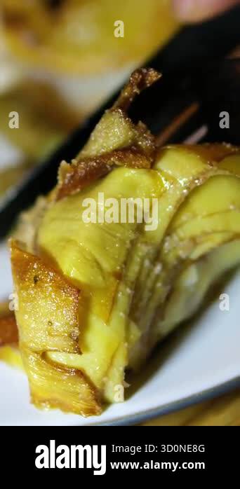 Close up of artichoke served on white plate sliced with knife and fork ...