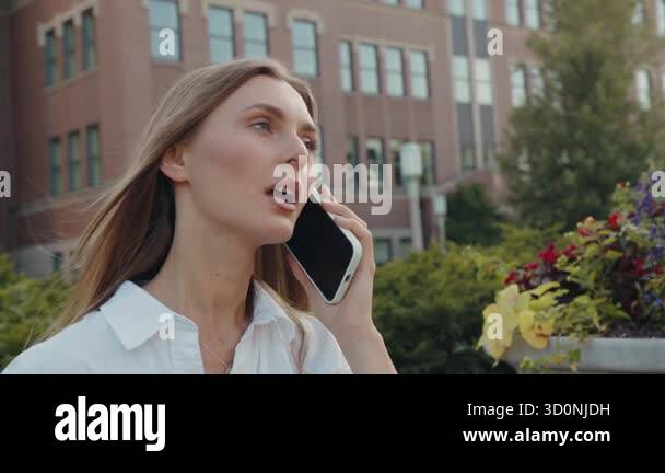 Caucasian lady woman walking in city talking phone conversation ...