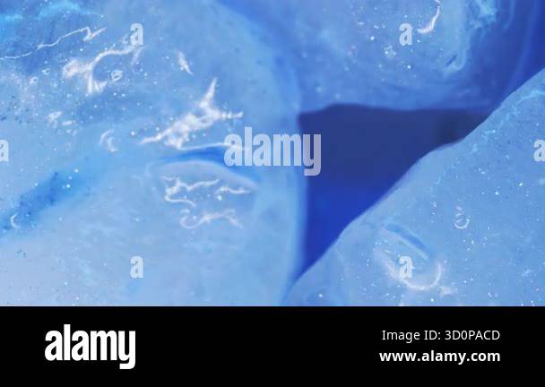 Vertical video. Frozen water. Shiny paint. Defocused blue color flowing ...