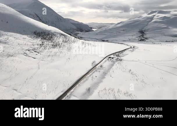 Drone flying forward along a curving mountain road that ascends to the ...
