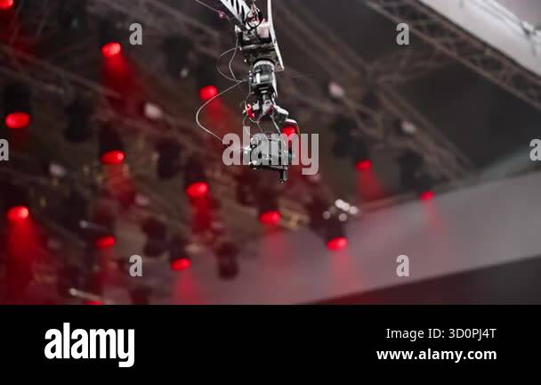 Camera crane captures an aerial view of a lively concert under bright ...