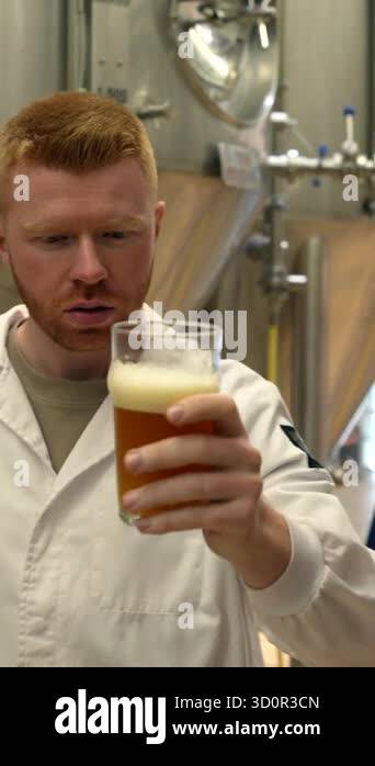 Knowledgeable brewmaster with red hair and a beard wearing a white lab ...