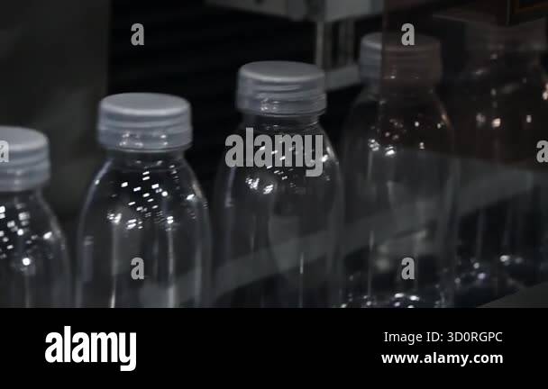 Slow motion scene full filled drinking water bottles on the conveyor ...