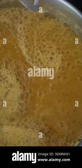 Blending vegetables with a hand blender to make soup at home. Creamy vegetable pure shows ...