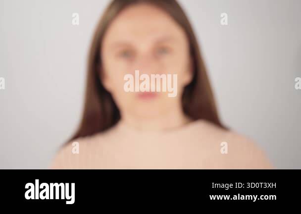 Blurred view of a tired woman taking off her eyeglasses and rubbing her ...
