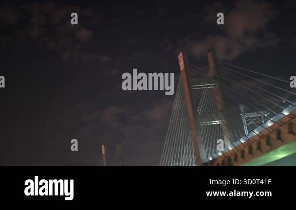 Suspension bridge illuminated at night with cables and support towers ...