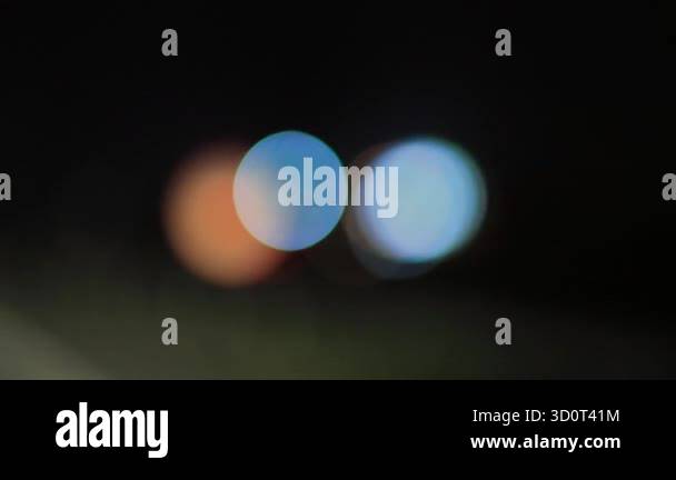 Defocused car headlights and colorful bokeh in dark background as seen ...