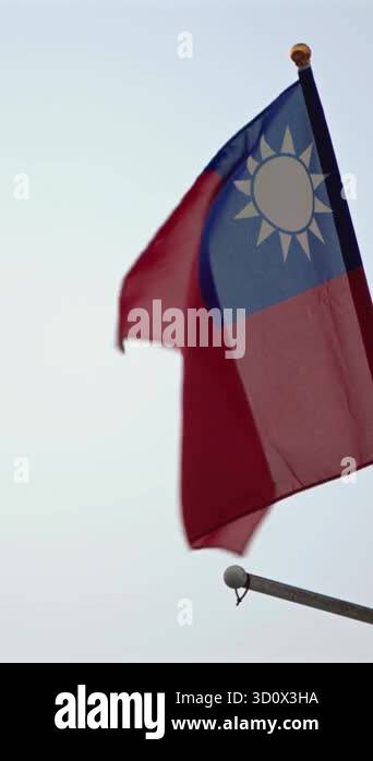 Vertical Slow motion of the Taiwan flag waving on a pole against a ...