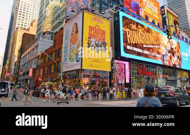 Crowded, ad-filled Times Square. Bright billboards illuminate Times ...