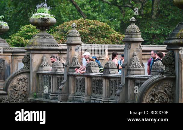 Tourists on Bethesda Terrace bridge in Central Park. People lean on the ...