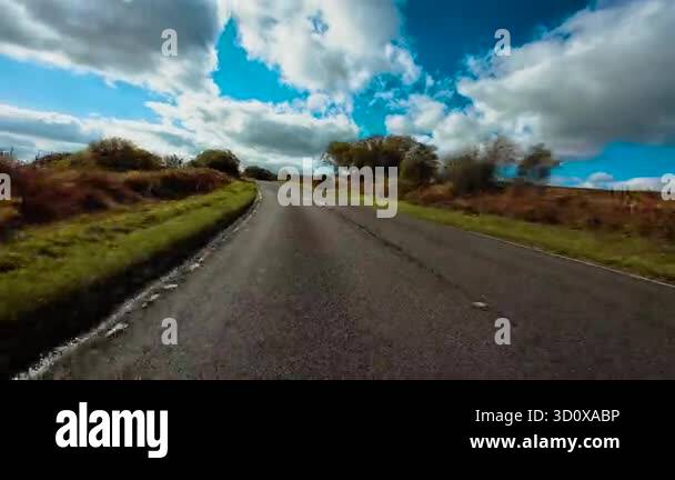 Car driving through countryside road with left hand traffic in England ...