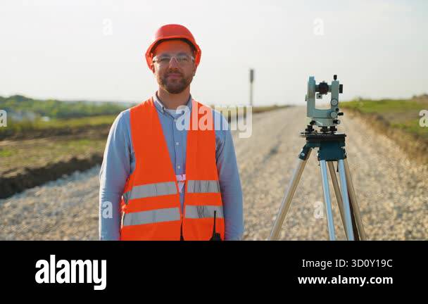 Portrait of a male caucasian land surveyor in a hard hat and safety ...