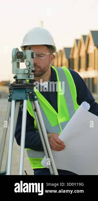 Caucasian professional male surveyor in a hard hat and high visibility ...