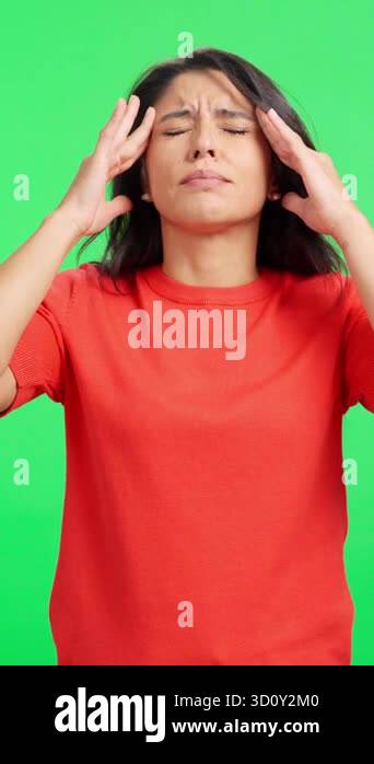 Young woman suffering from a painful headache, massaging her temples on ...