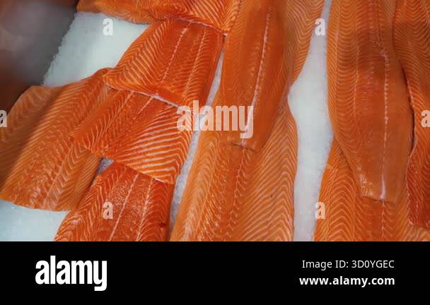 The fresh salmon fillets displayed on a bed of ice in a supermarket ...