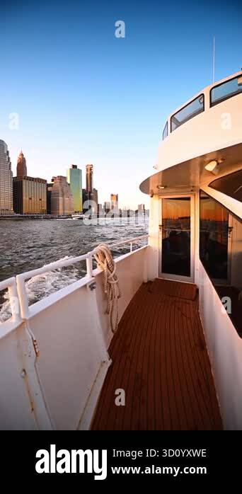 Boat Cruising along Manhattan Waterfront. A boat cruises along the East ...