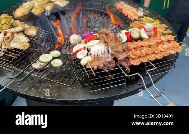 Various meats and veggies cooked on hot grill fire, tasty barbecue ...