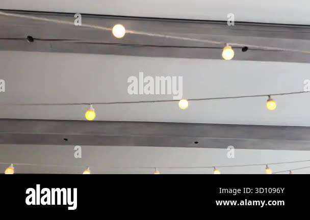 Soft glowing string lights hanging from a wooden ceiling in a cozy ...