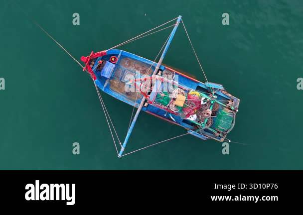 Wooden fishing boat floating offshore in Vietnam, red flag with yellow ...