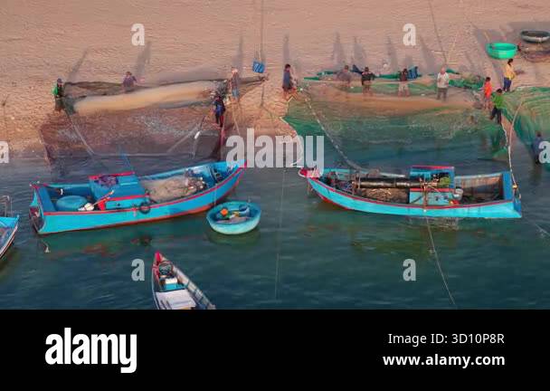 Aerial view of fishermen hauling nets on beach, authentic culture ...