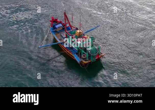 Wooden fishing boat floating offshore in Vietnam, red flag with yellow ...