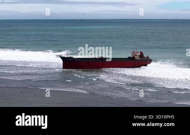 Aerial view, top view of old rusty stranded logistics ship on the beach ...