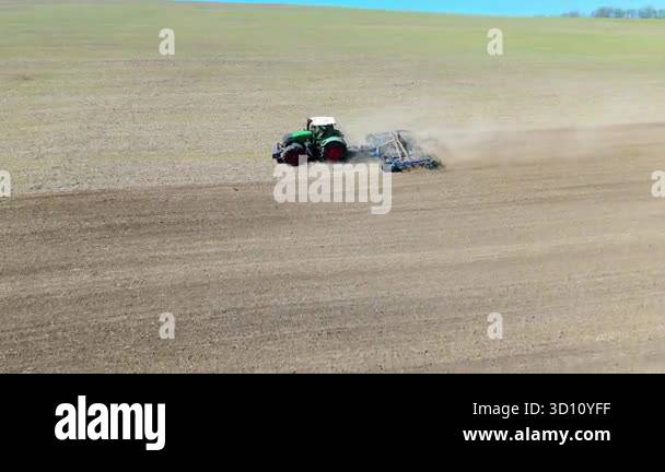 Agricultural tractor is actively plowing the field, capturing the ...