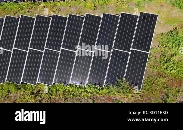 Aerial perspective highlights solar panels in rows, surrounded by lush ...
